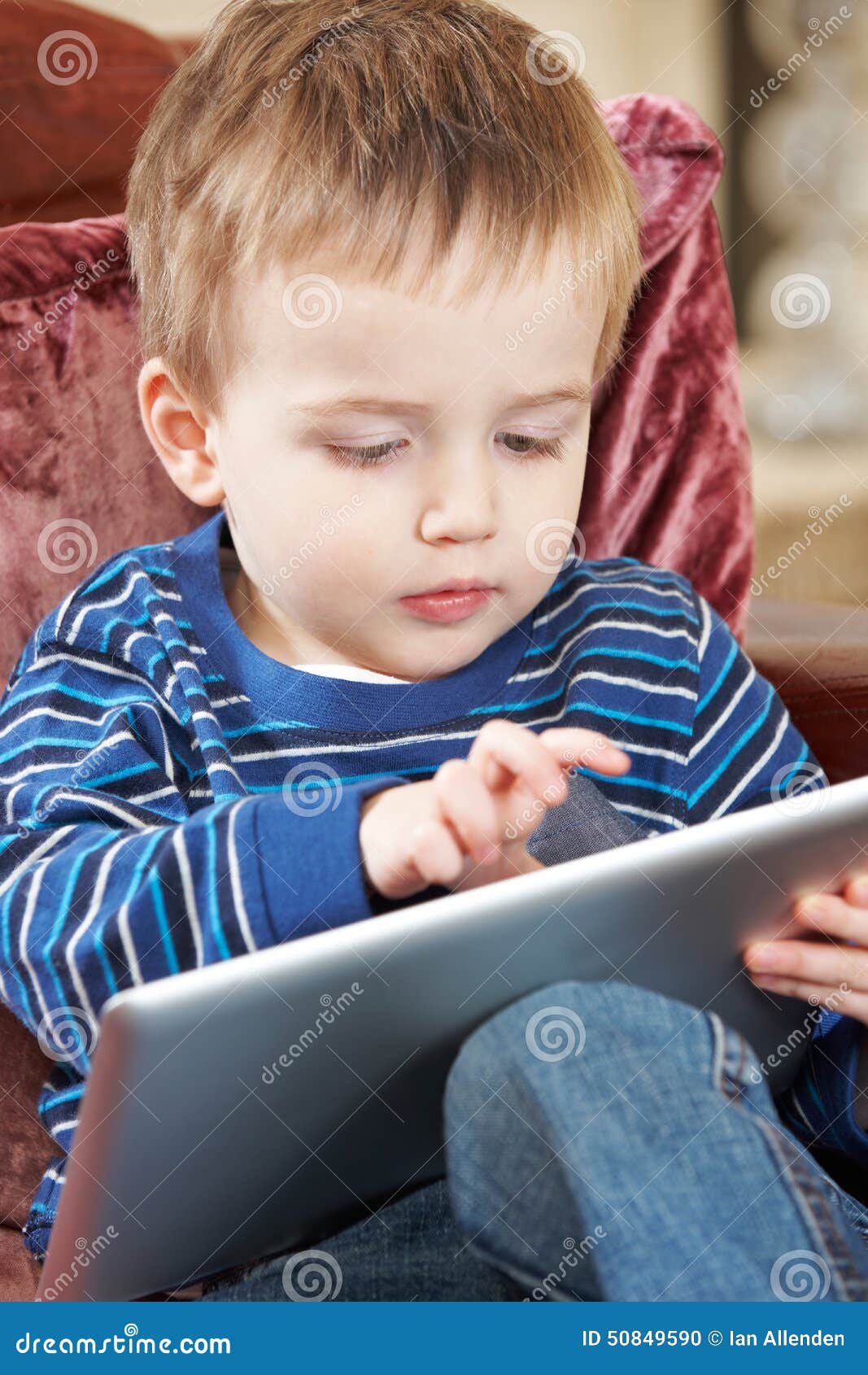 Boy Sitting on Sofa and Playing with Digital Tablet Stock Photo - Image ...