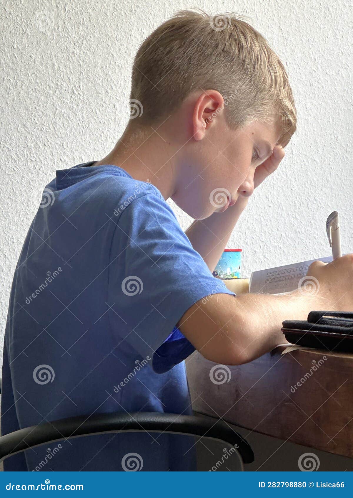 Boy sitting at the table stock photo. Image of schoolboy - 282798880