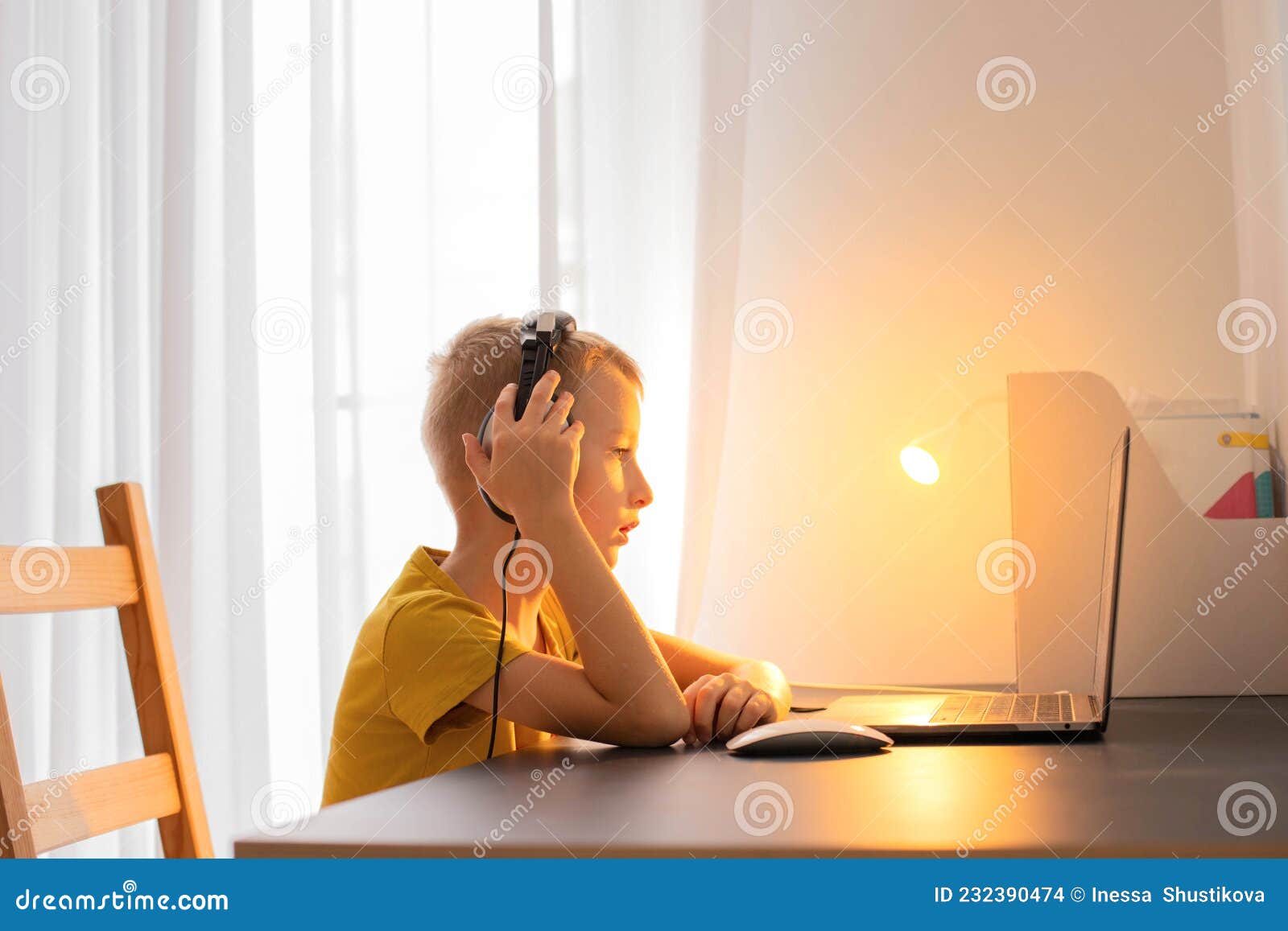 The Boy is Sitting at the Table in the Children`s Room and Playing ...