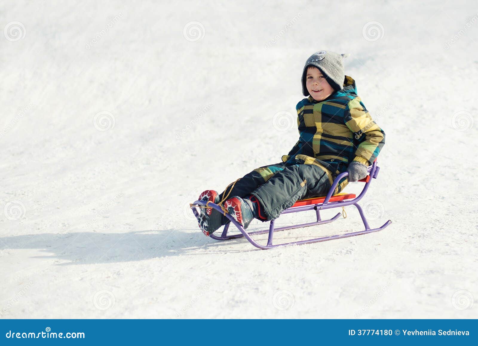 Boy on a Sled in the Snow stock photo. Image of slide - 37774180