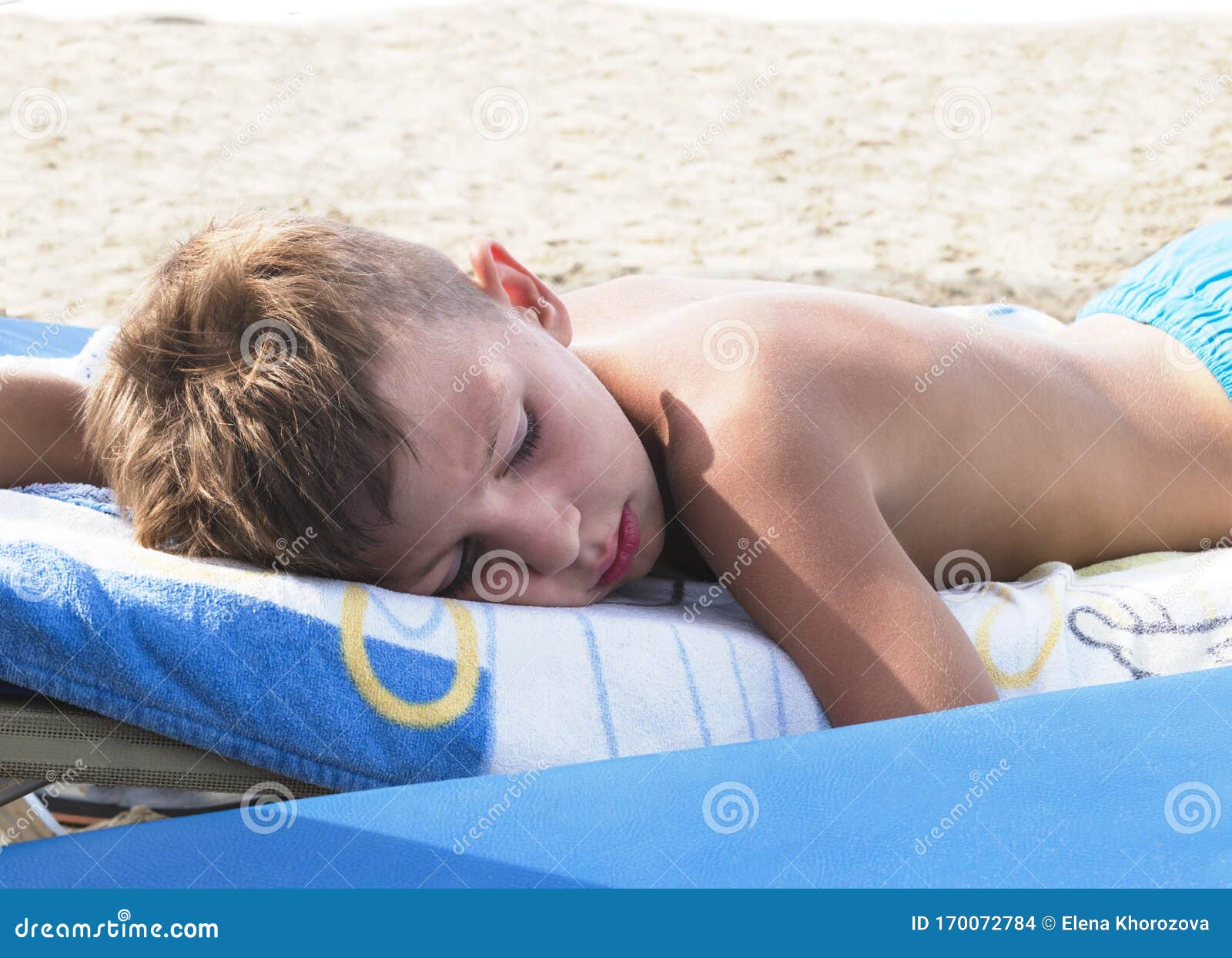 A Boy Sleeps on the Beach Under Strong Sunlight. Danger of Sunstroke or ...