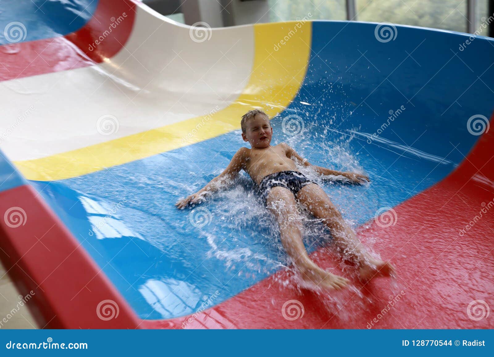 Boy on water slide stock photo. Image of resort, holiday - 128770544