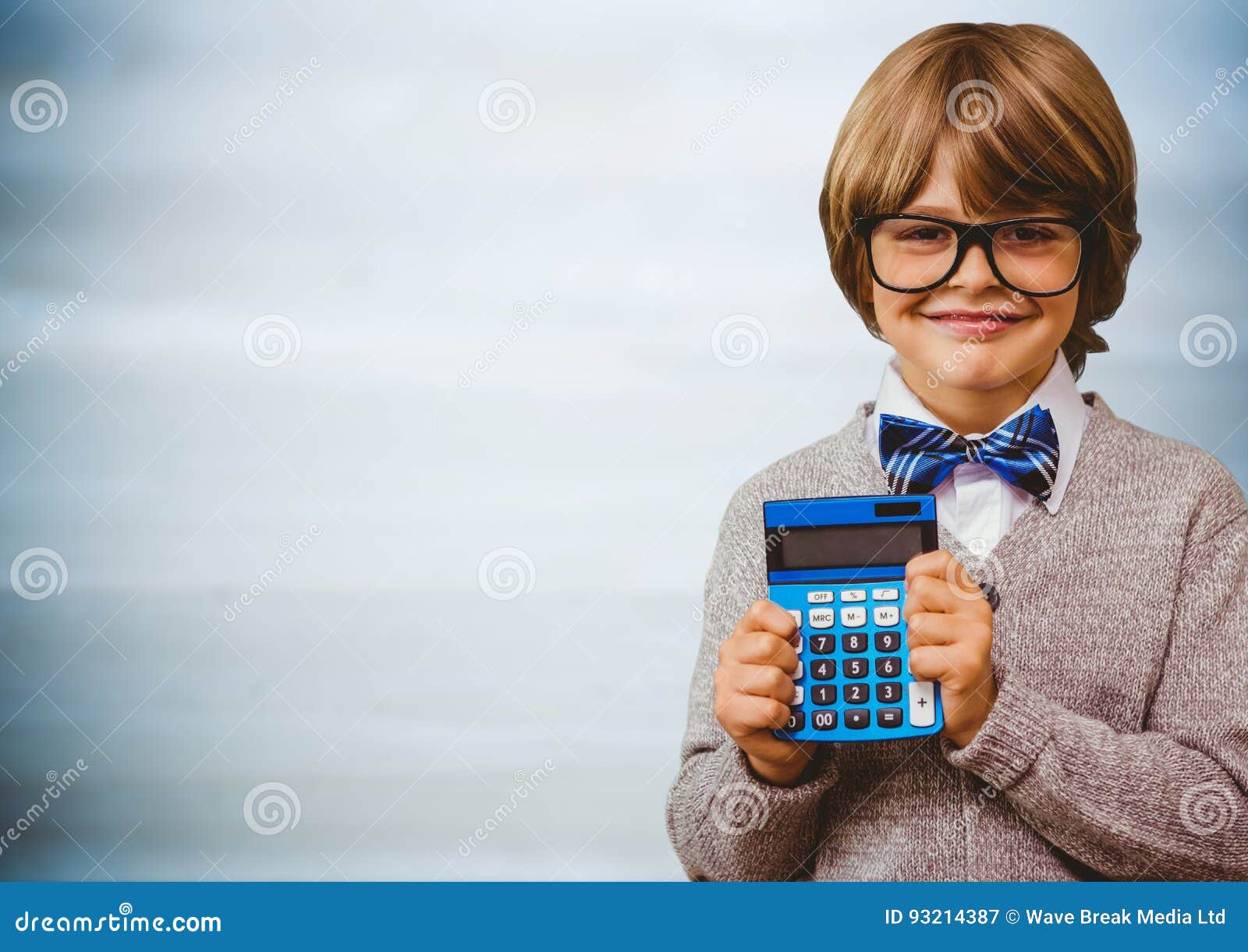 Boy Smiling with Calculator Against Blurry Blue Wood Panel Stock Image ...