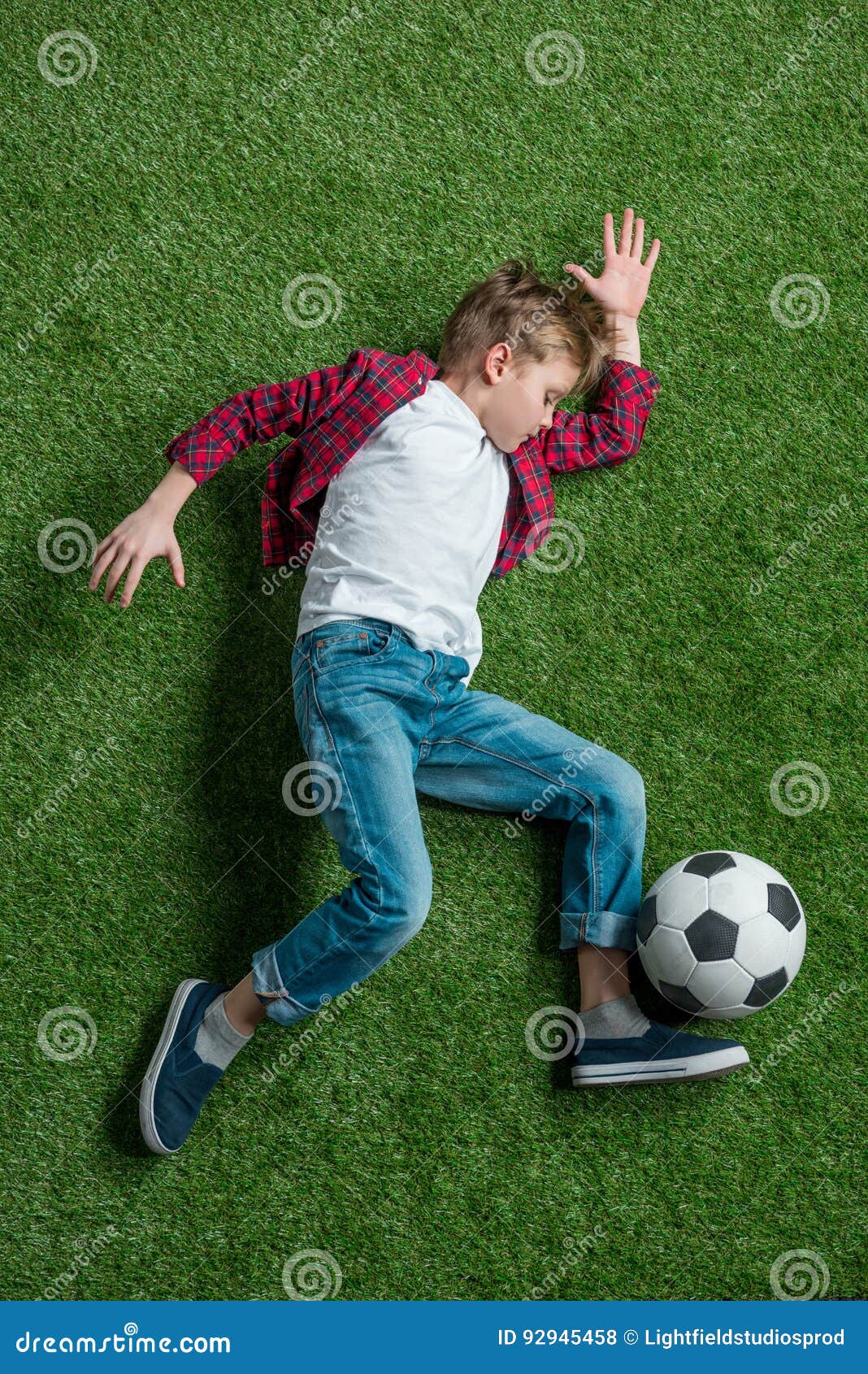 Boy with Soccer Ball Lying on Green Grass Stock Photo - Image of ...