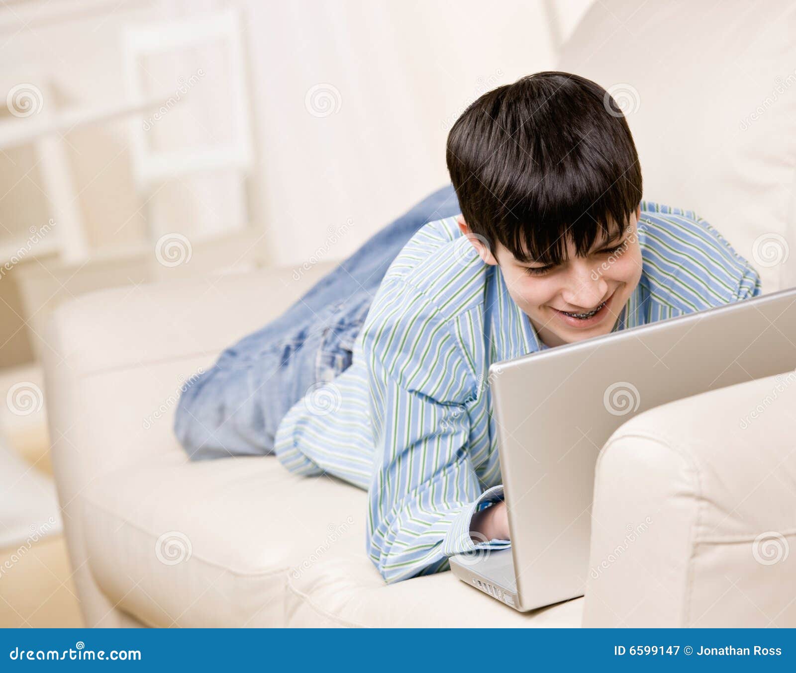 Boy on Sofa in Livingroom Using Laptop Stock Image - Image of teen ...