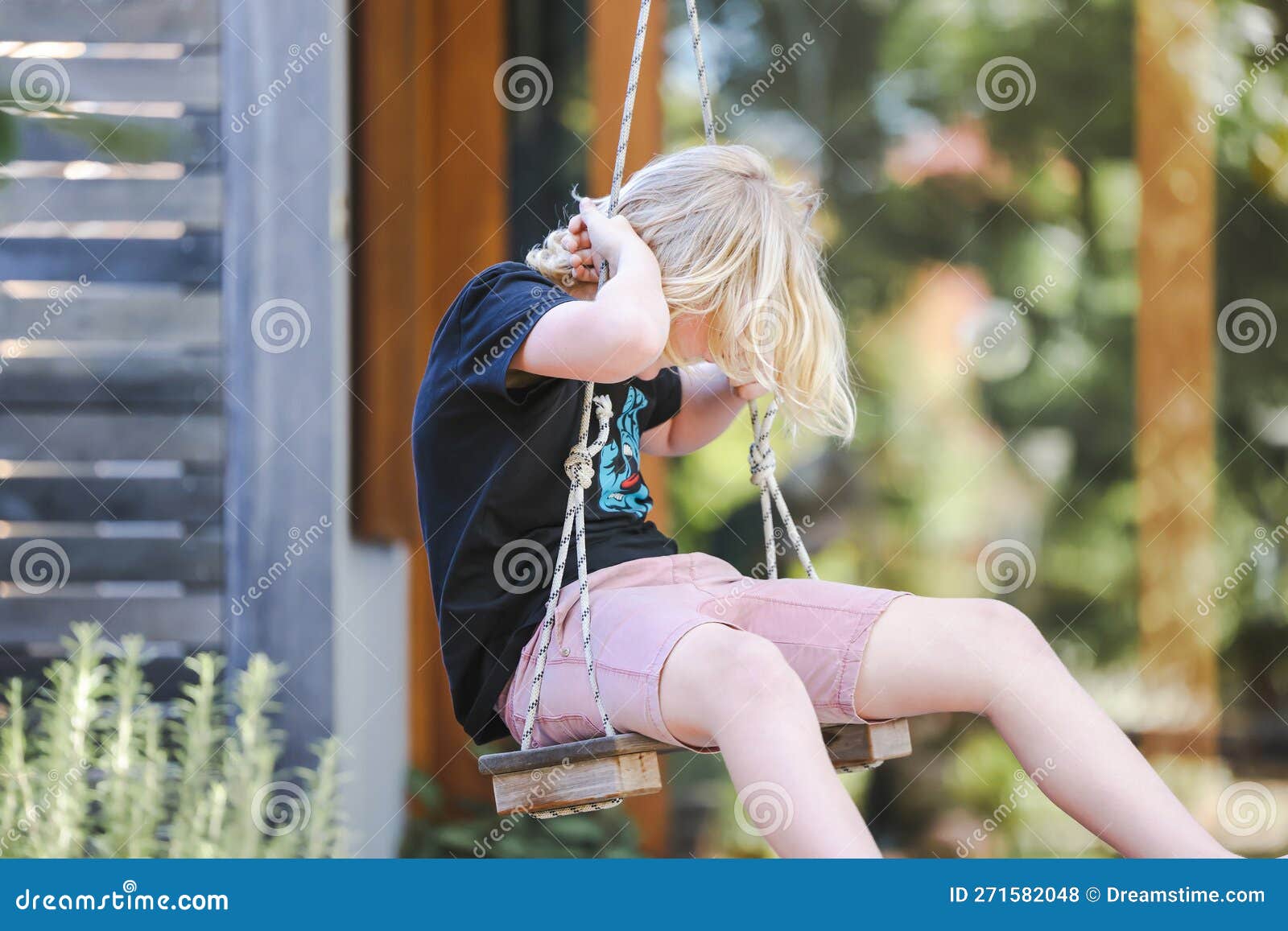 Boy Spinning on Backyard Swing on a Tranquil Patio on a Beautiful ...