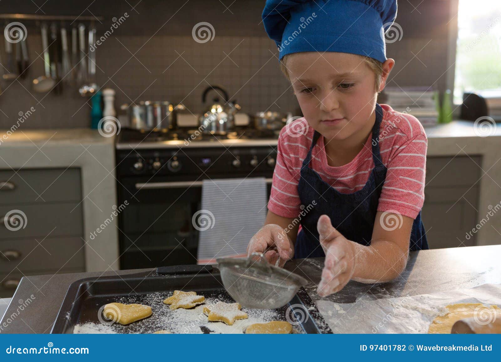 Boy Sprinkling Flour on Cookies Stock Photo - Image of abode, household ...