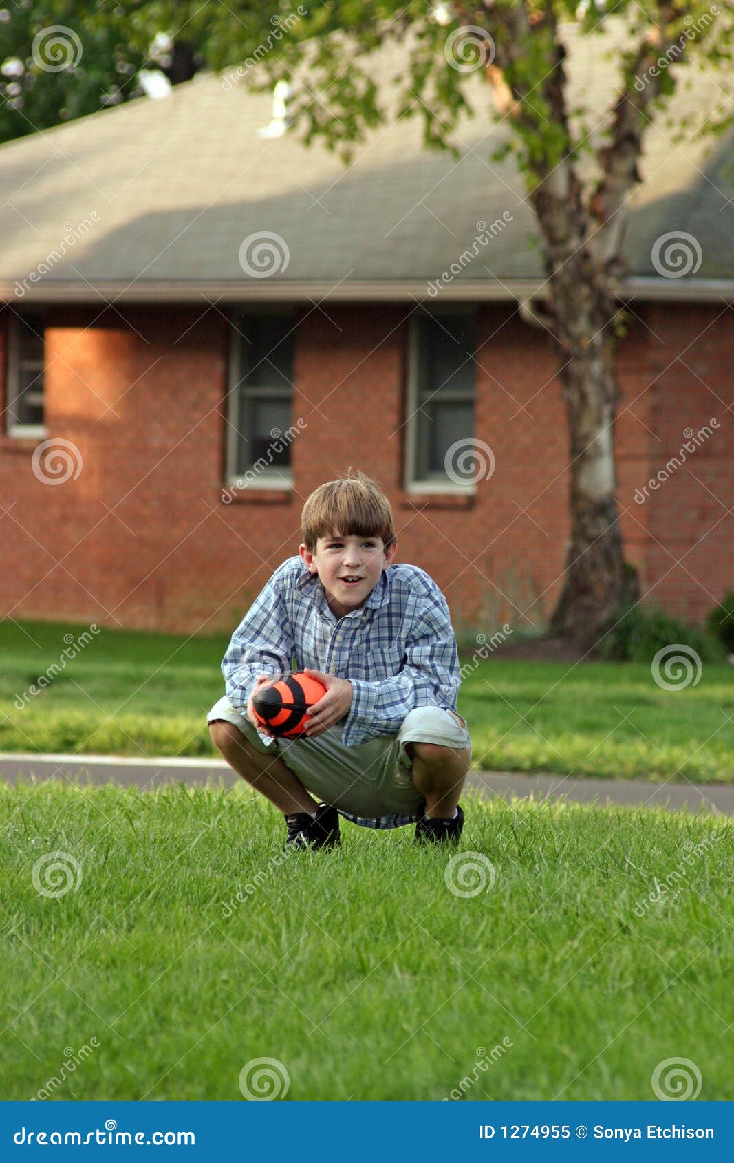Boy Squatting Holding Football Stock Image - Image of tackle, people ...