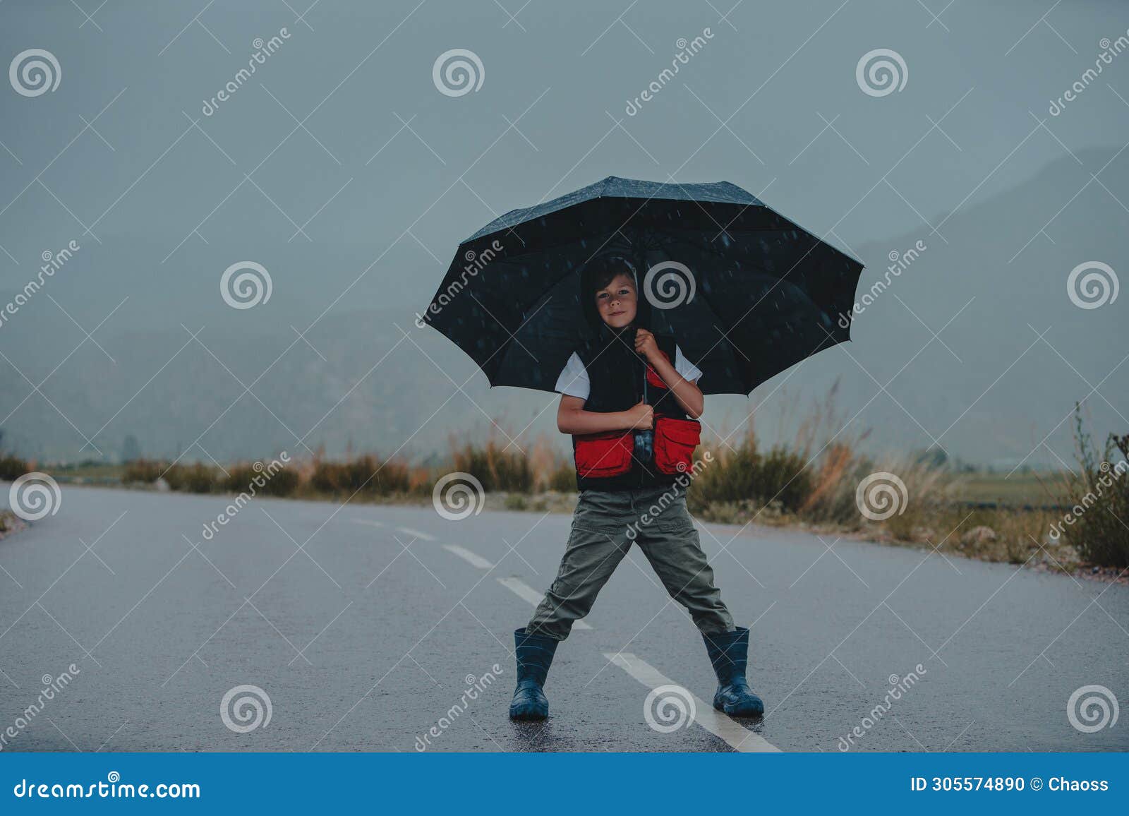 Boy Standing on the Road with Umbrella in Rainy Weather Stock Photo ...