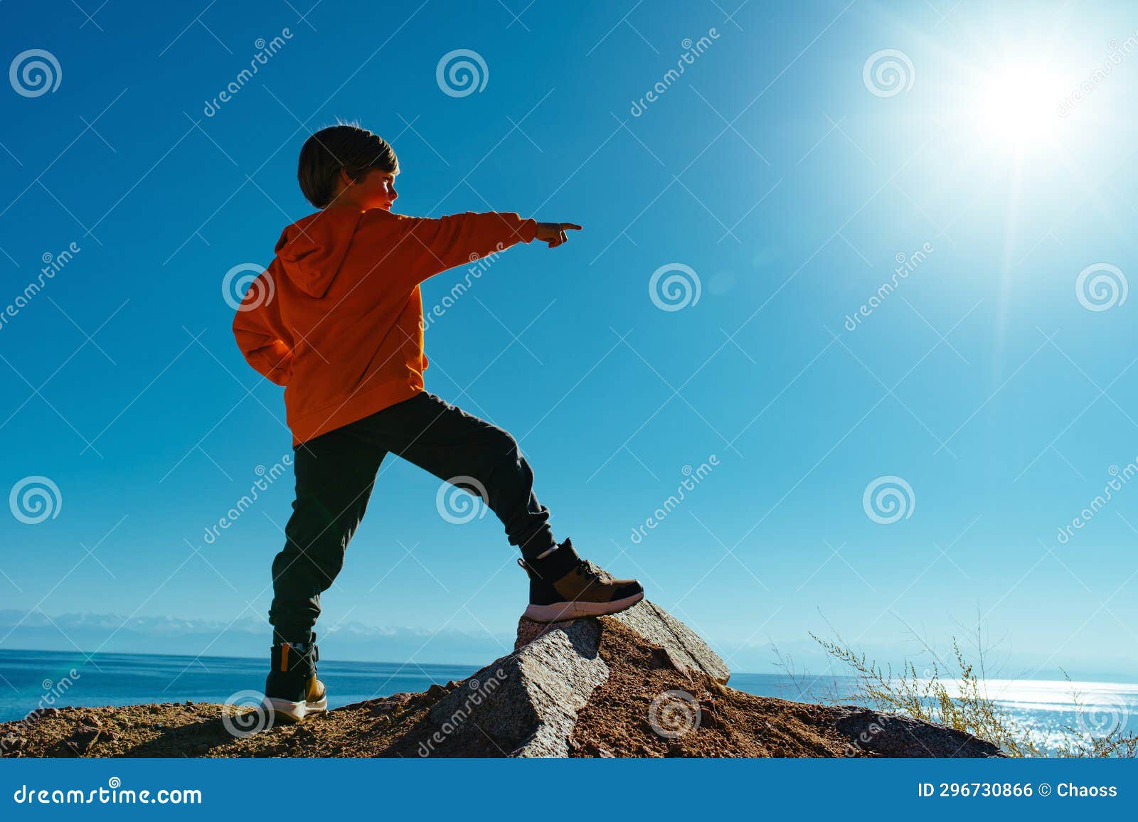 Boy Standing on Top of Mountain and Points into the Distance Stock ...