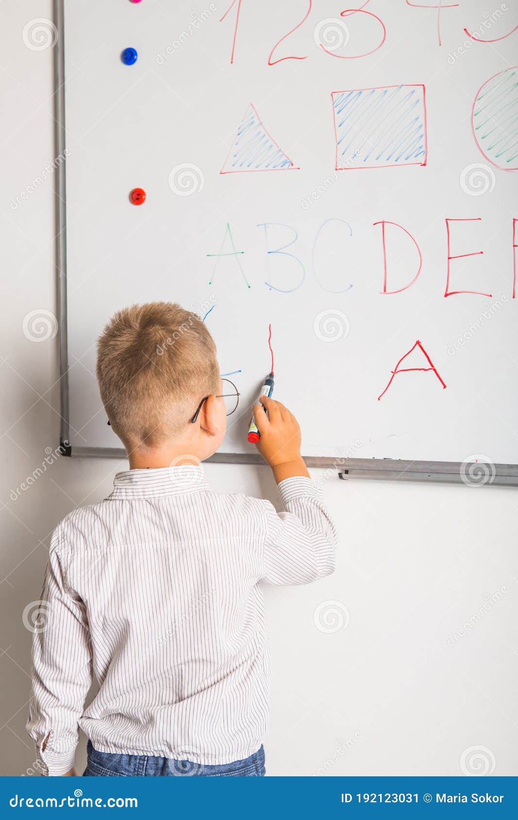 A Boy Stands with His Back in Front of a Blackboard at School. Math ...