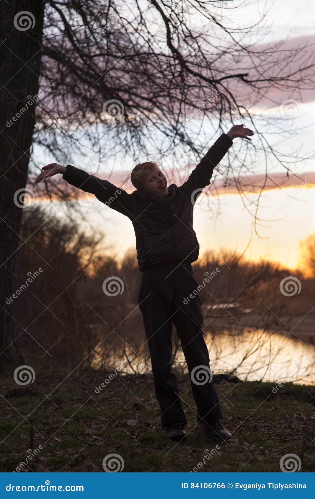 Boy stands in the sunset stock photo. Image of field - 84106766