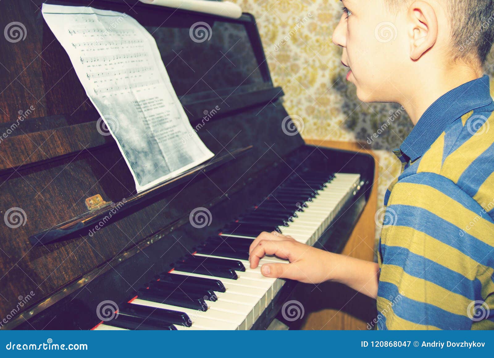 The Boy Studies Chords on Notes, Sitting at the Piano. Stock Image ...