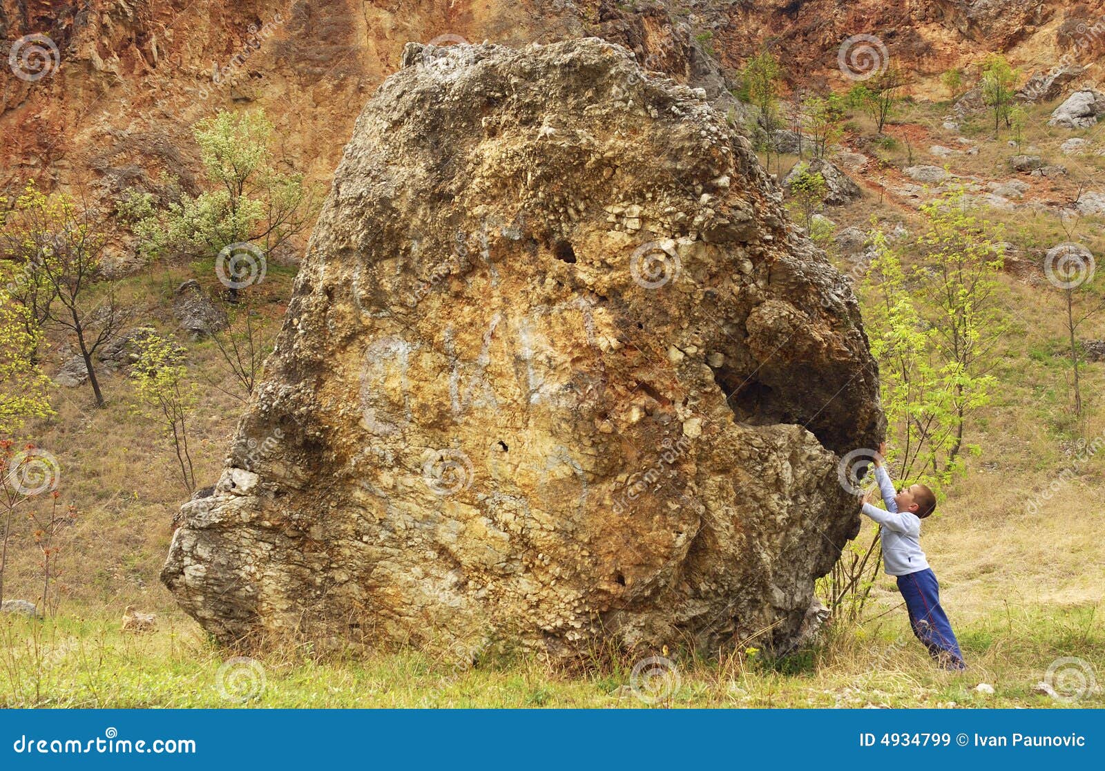 Boy supporting a rock stock image. Image of healthy, holding - 4934799