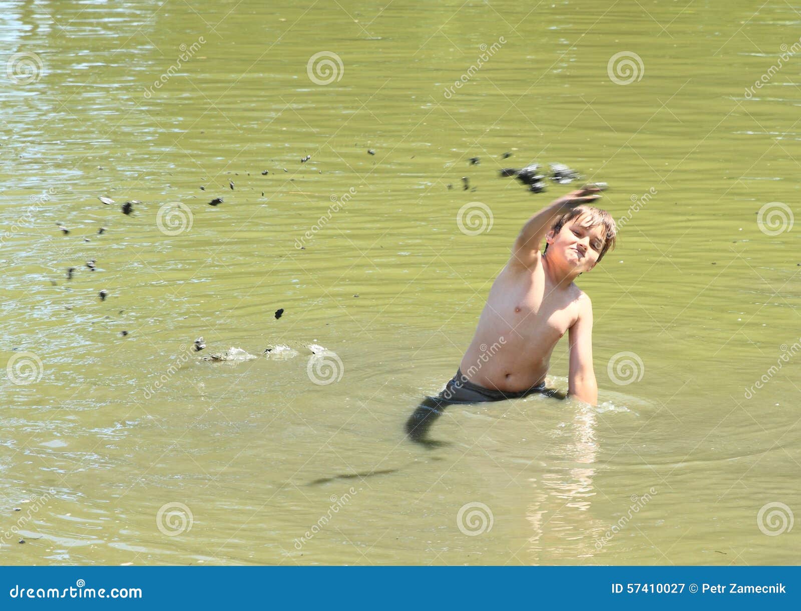 Boy throwing mud in water stock image. Image of pond - 57410027