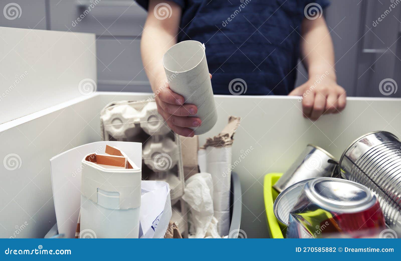 The Boy is Throwing the Paper Garbage To the One of Four Different Bins ...