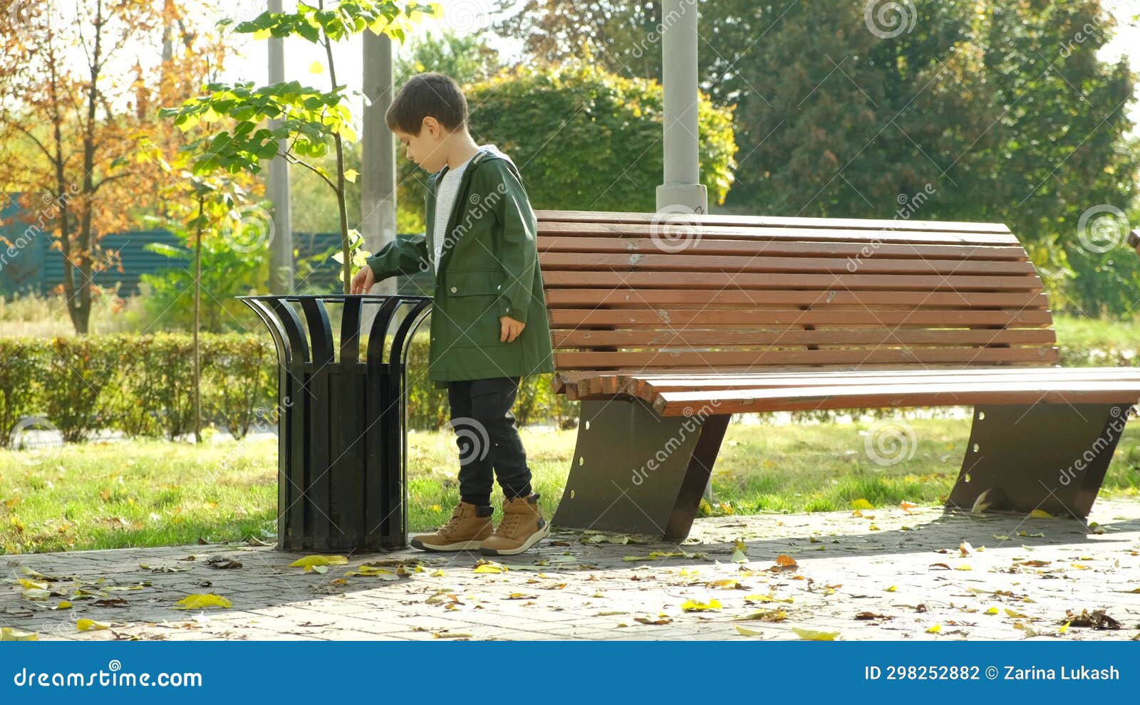 A Boy Throws Garbage in a Trash Can in the Park. Stock Footage - Video ...
