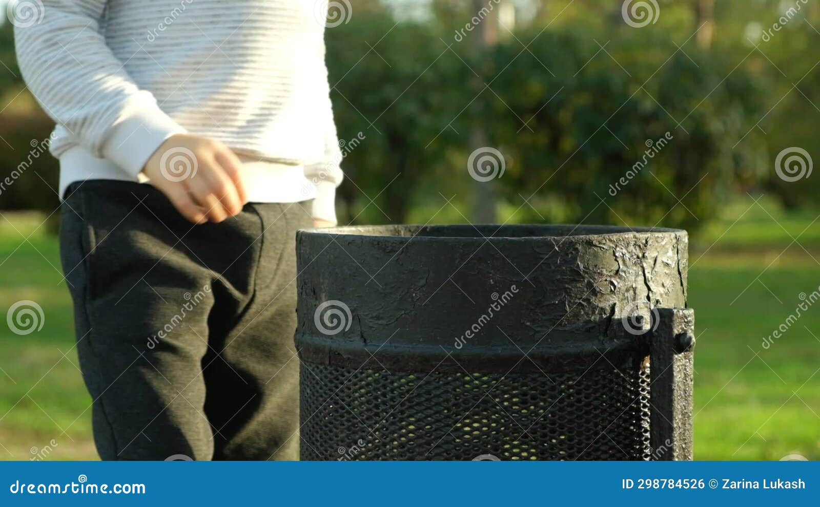 A Boy Throws Garbage in a Trash Can in the Park. Stock Footage - Video ...