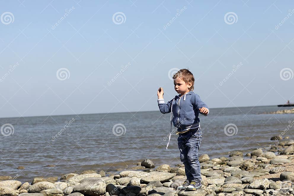 Boy throws pebbles stock photo. Image of childhood, coastline - 49799802