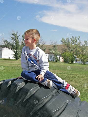 Boy on tire. stock image. Image of person, playground - 3098277