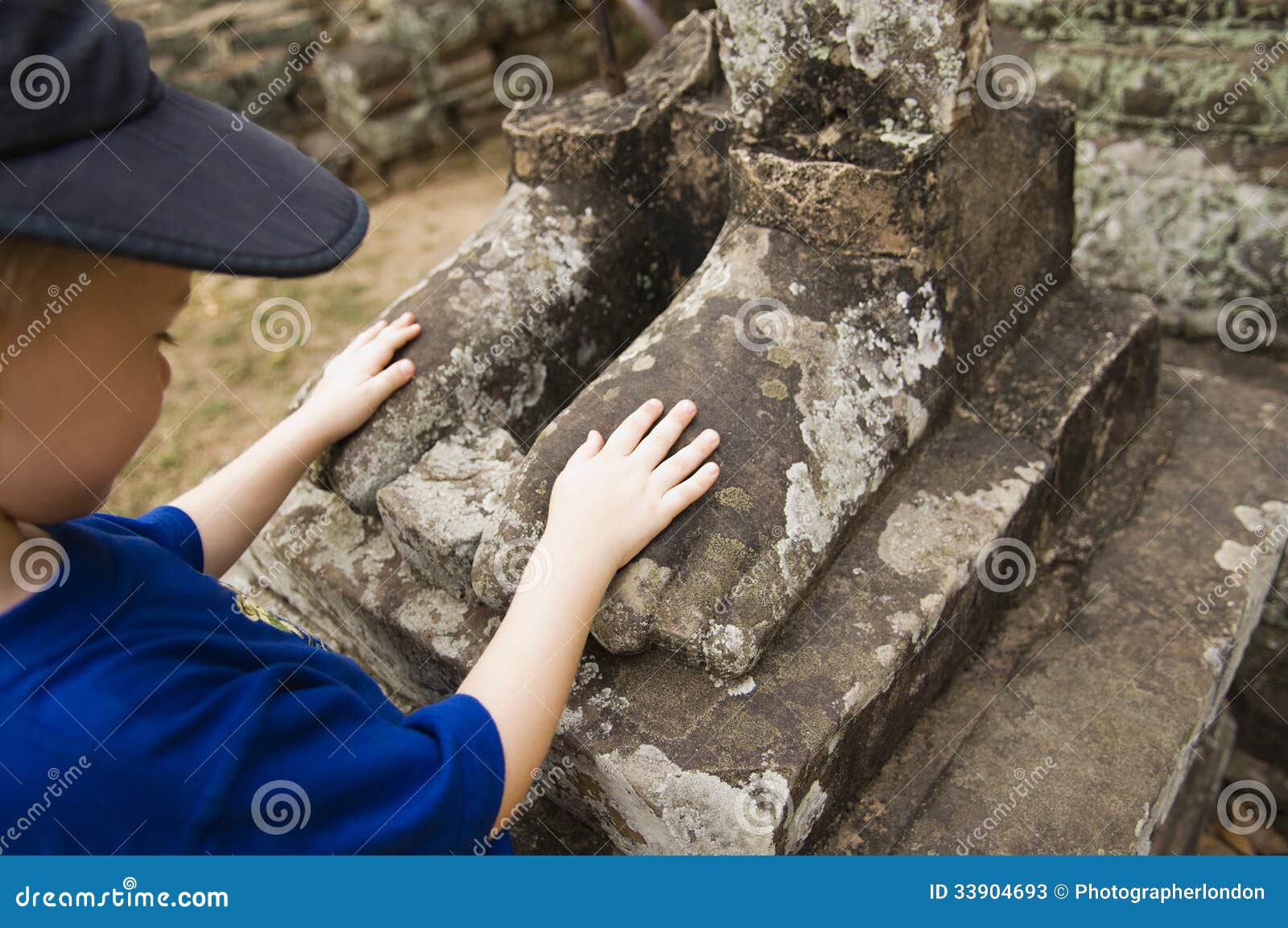 Boy Touching Feet of Ancient Statue Stock Image - Image of people, foot ...