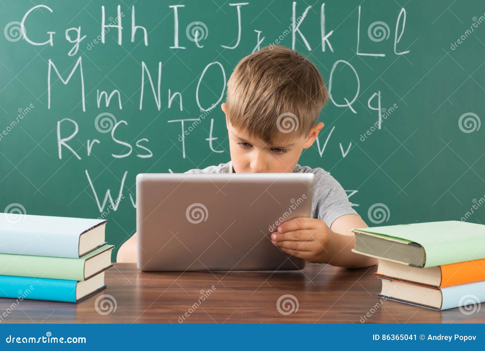 Boy Using Digital Tablet in Classroom Stock Image - Image of child ...