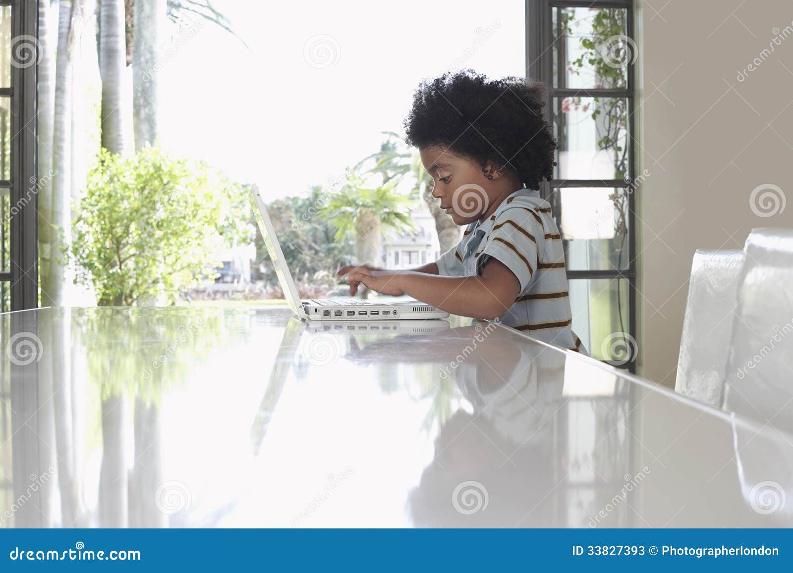 Boy Using Laptop at Dining Table Stock Image - Image of childhood, male ...