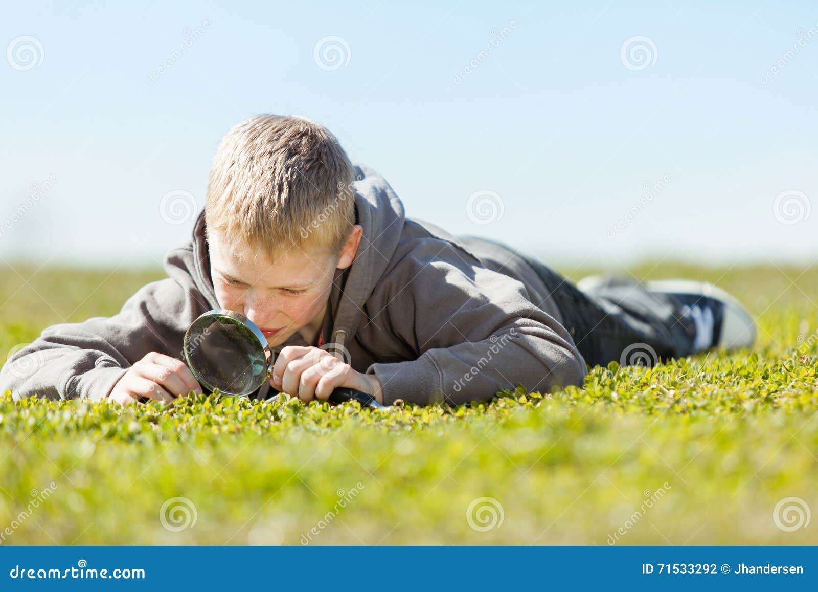 Boy Using Magnifying Glass Over Field of Grass Stock Photo - Image of ...