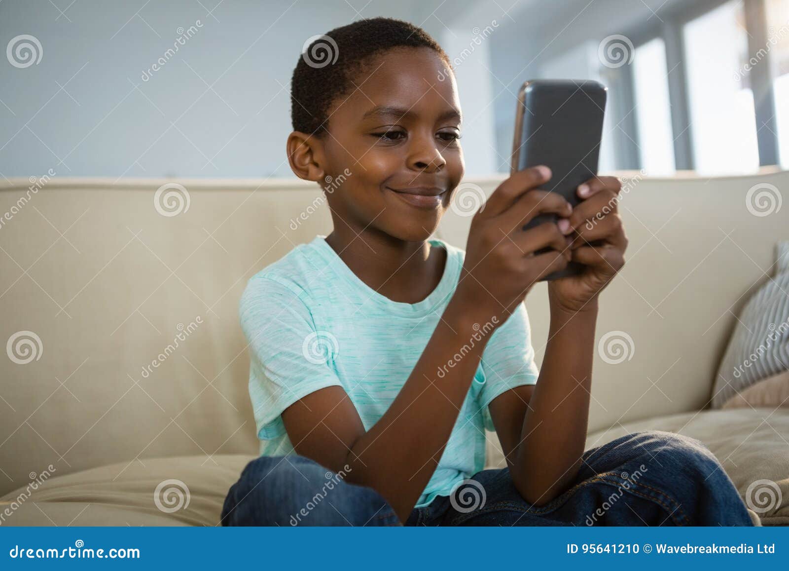 Boy Using Mobile Phone in the Living Room Stock Photo - Image of couch ...