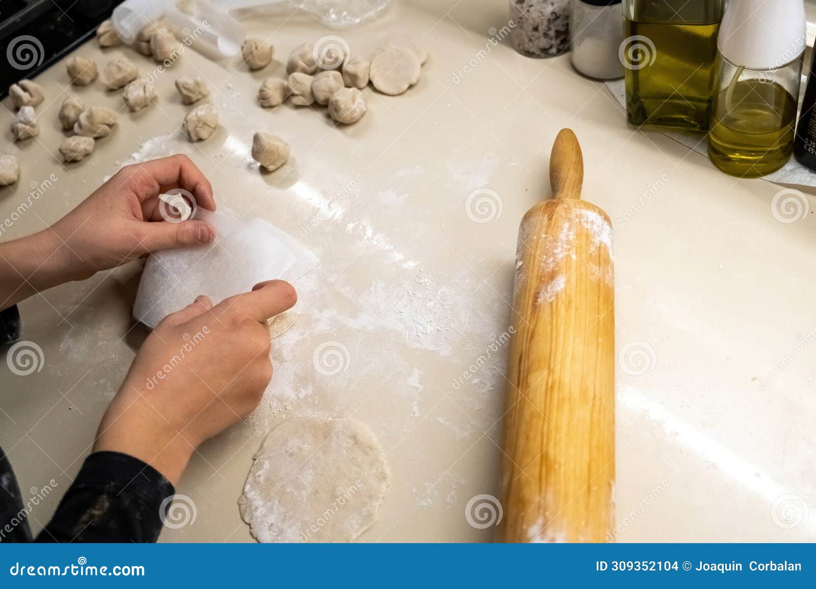 A Boy, Using a Rolling Pin To Flatten Dough on a Kitchen Counter Stock ...