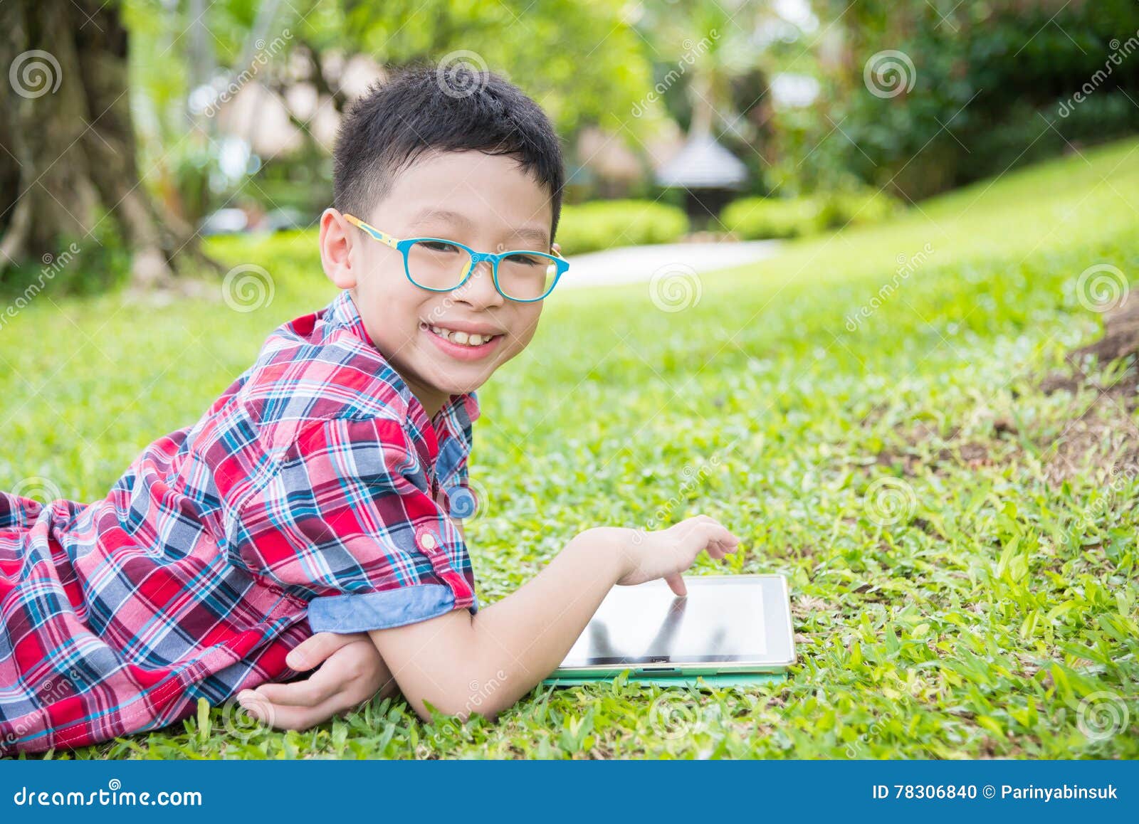 Boy Using Tablet Computer in Park Stock Photo - Image of male, looking ...