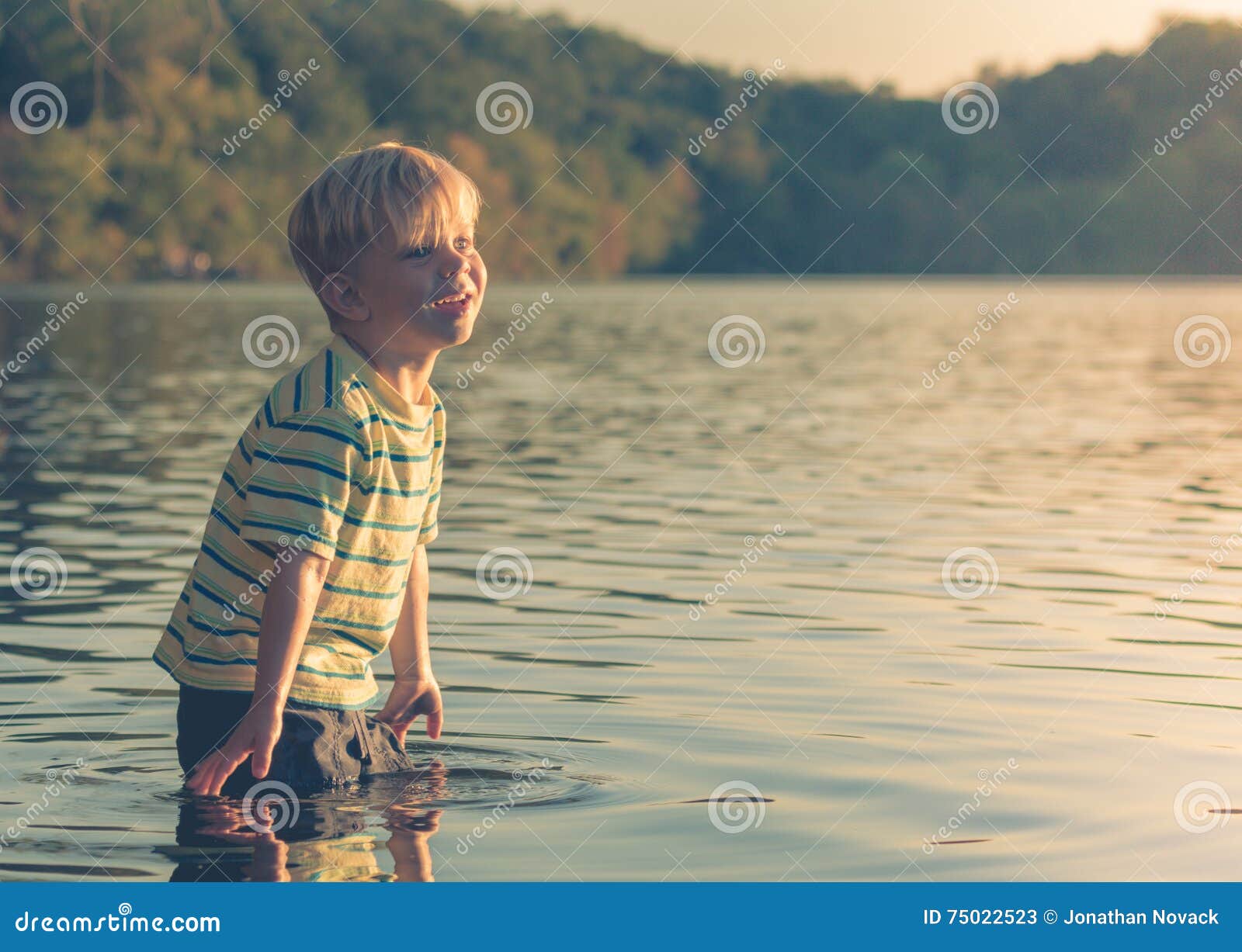 Boy Wading into Lake stock image. Image of young, faded - 75022523