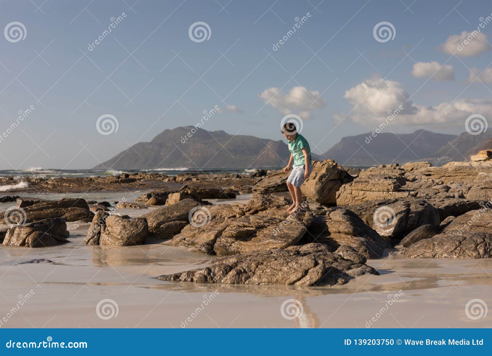 Boy Walking on Rocks at Beach Stock Photo - Image of holiday, casual ...