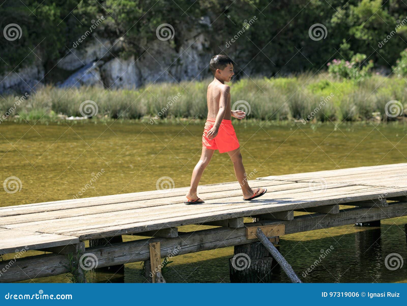 Boy Walking on a Wooden Foot Bridge on a Lake Stock Photo - Image of ...