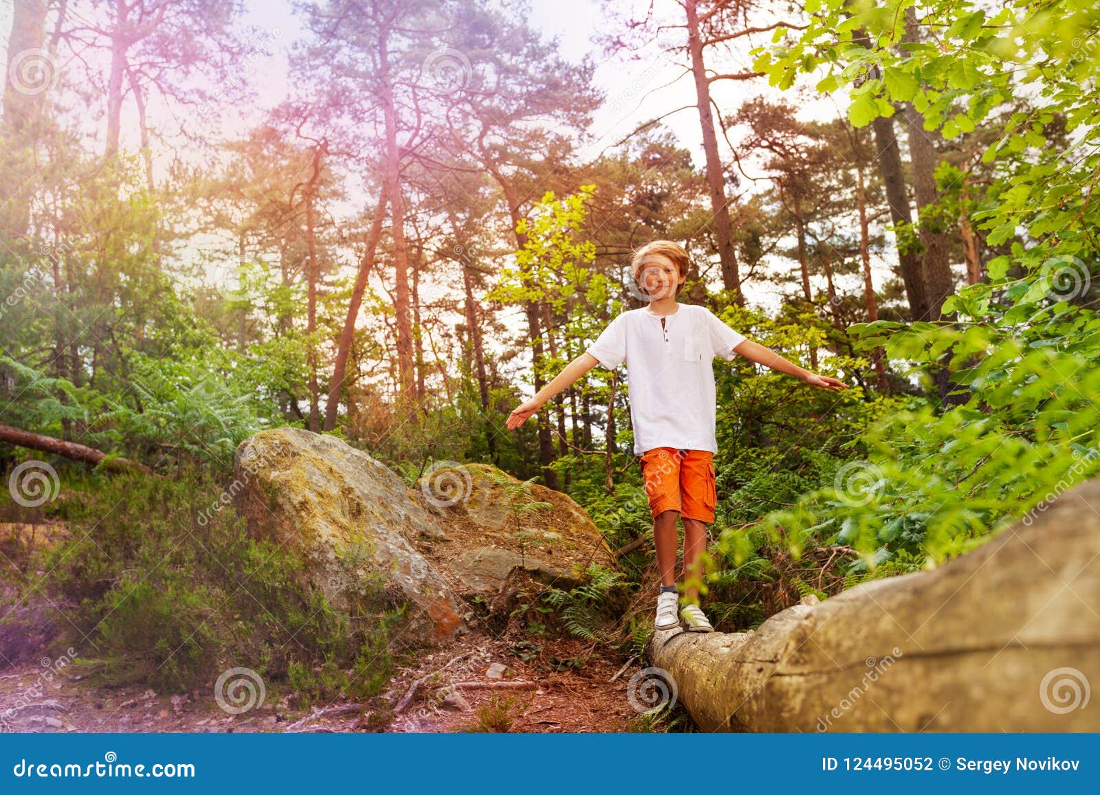 Boy Walks Over Log in the Forest Balance with Hand Stock Photo - Image ...