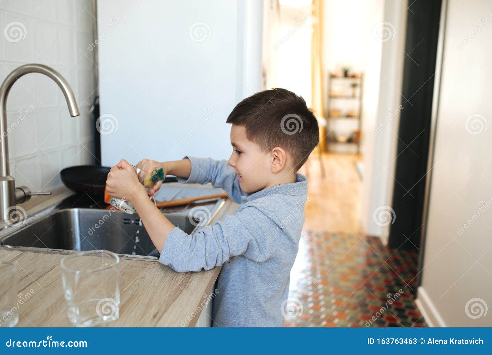 Little Boy Washing Dishes and Cleaning the Kitchen after Making Dinner ...