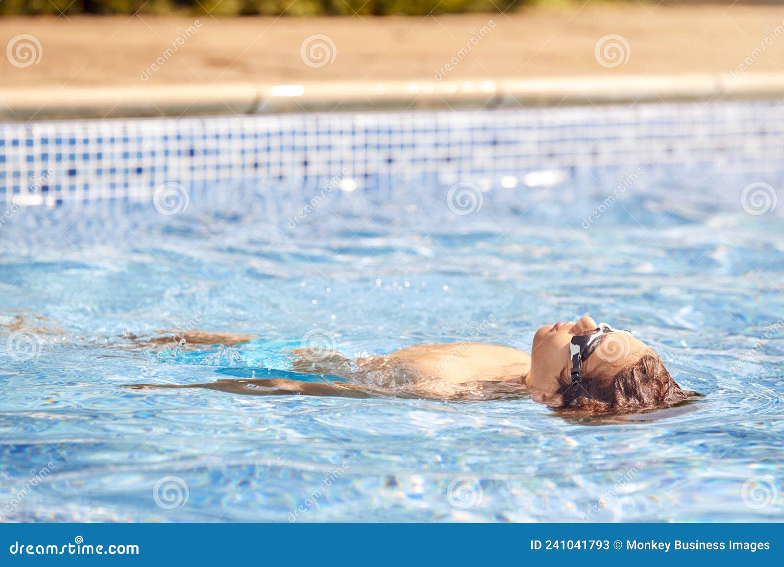 Boy Wearing Goggles Floating on Back in Swimming Pool on Summer ...