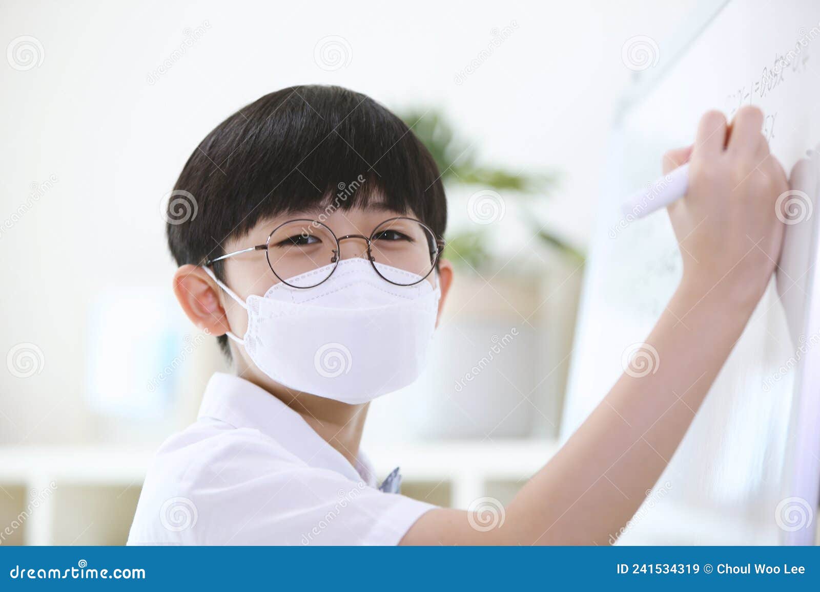 A Boy Wearing a Mask Smiling Brightly while Solving Problems in Front ...