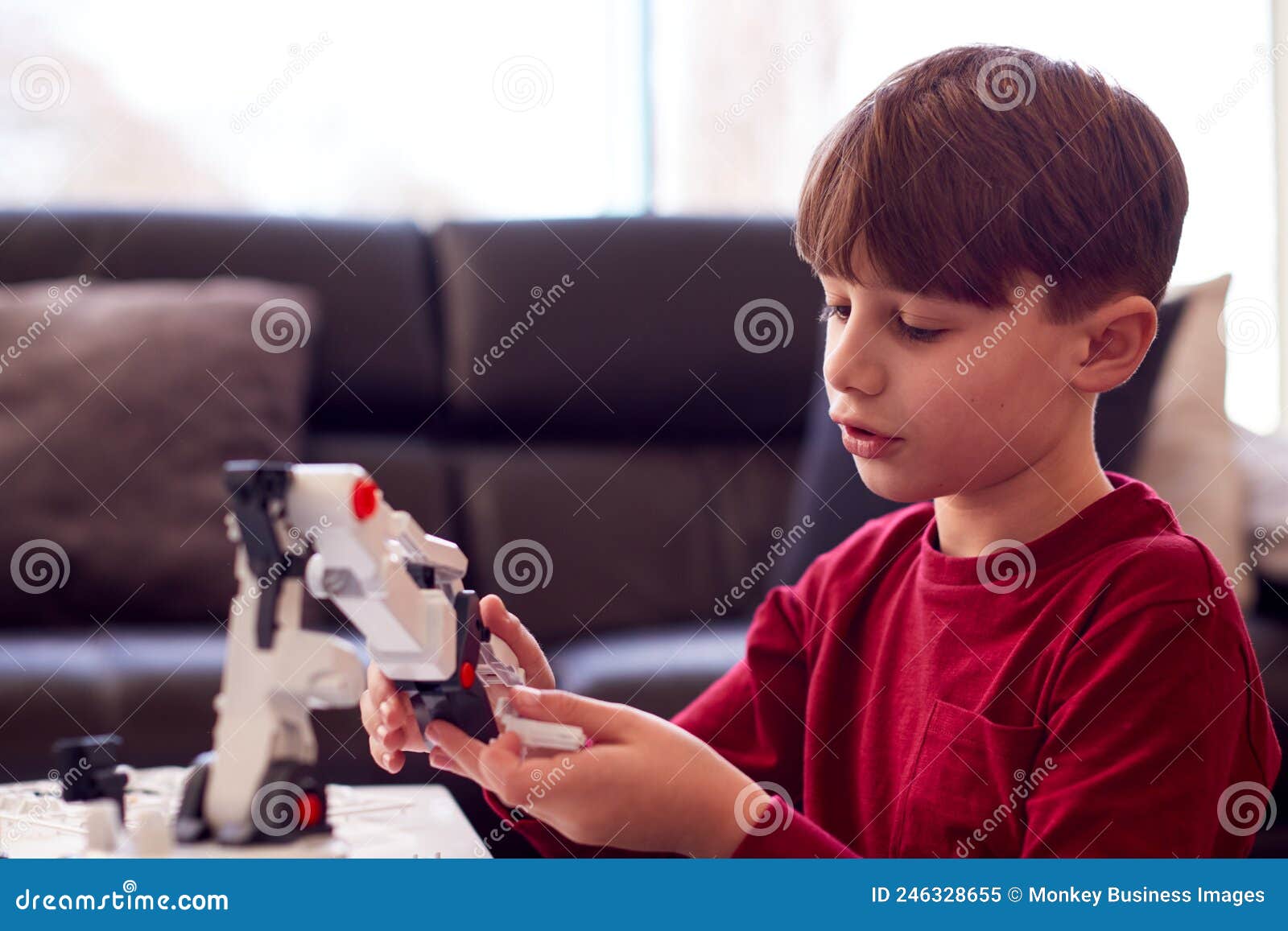 Boy Wearing Pyjamas Building Robotic Arm from Plastic Kit at Home Stock ...