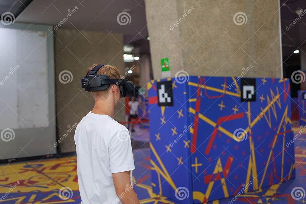 Boy Wearing a Virtual Reality Visor Inside a Play Space Set Up for the ...