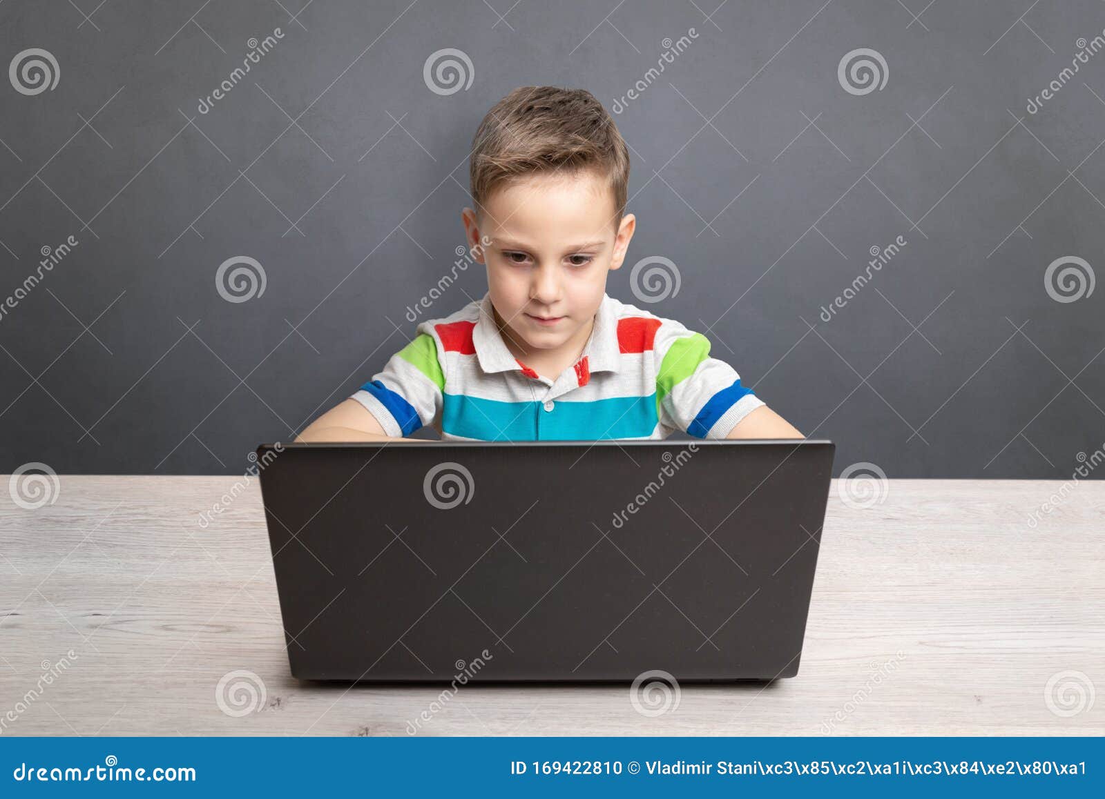 Boy Works on a Laptop Computer and a Desk. Concept of Using Computers ...