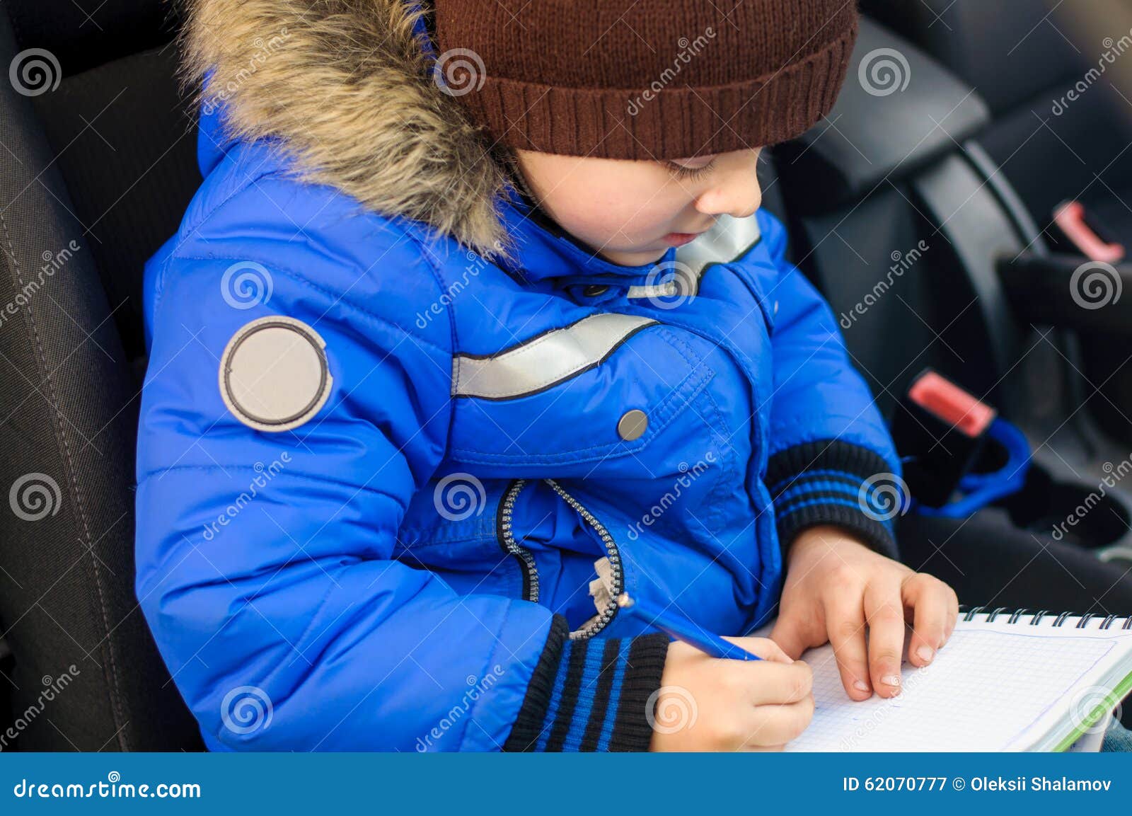 Boy Writes in Notebook Sitting Inside the Car Stock Image - Image of ...