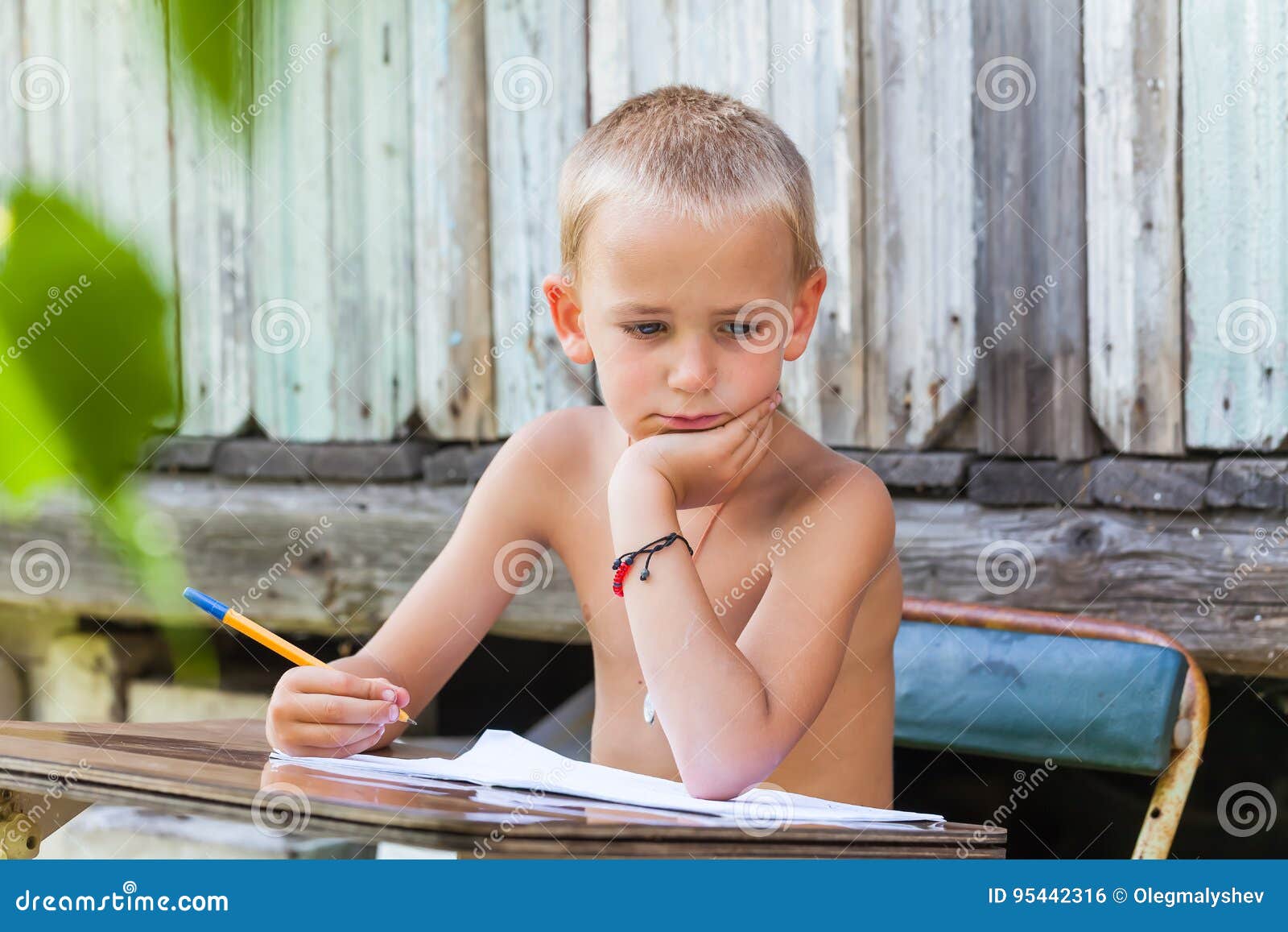 The Boy Writes while Sitting at the Table Lessons Stock Photo - Image ...