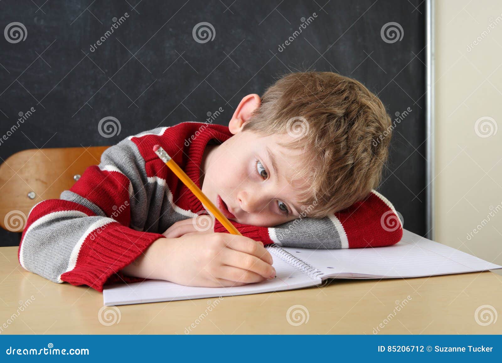 Boy writing at his desk stock photo. Image of head, writes - 85206712