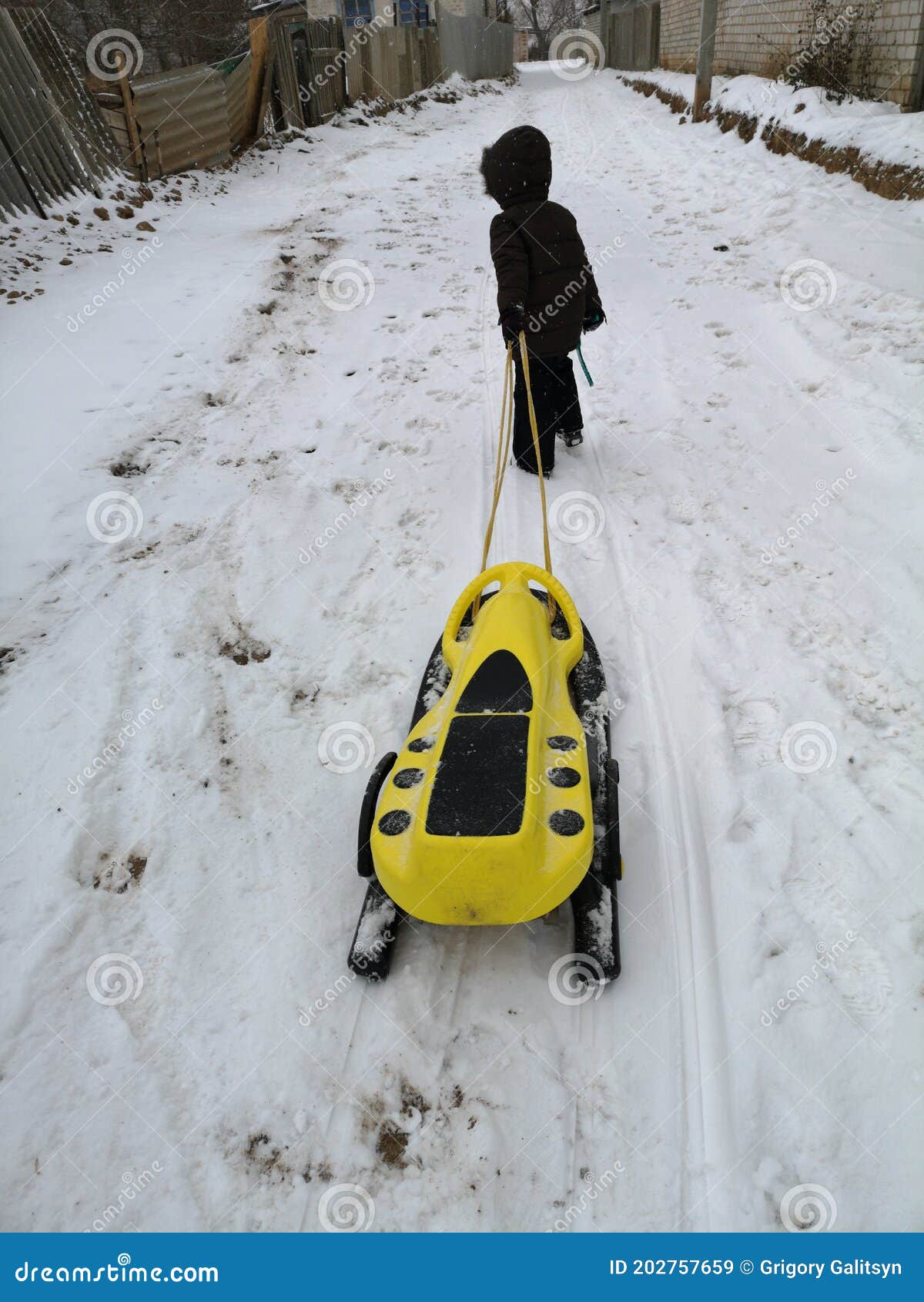 Boy with yellow sled stock image. Image of footwear - 202757659