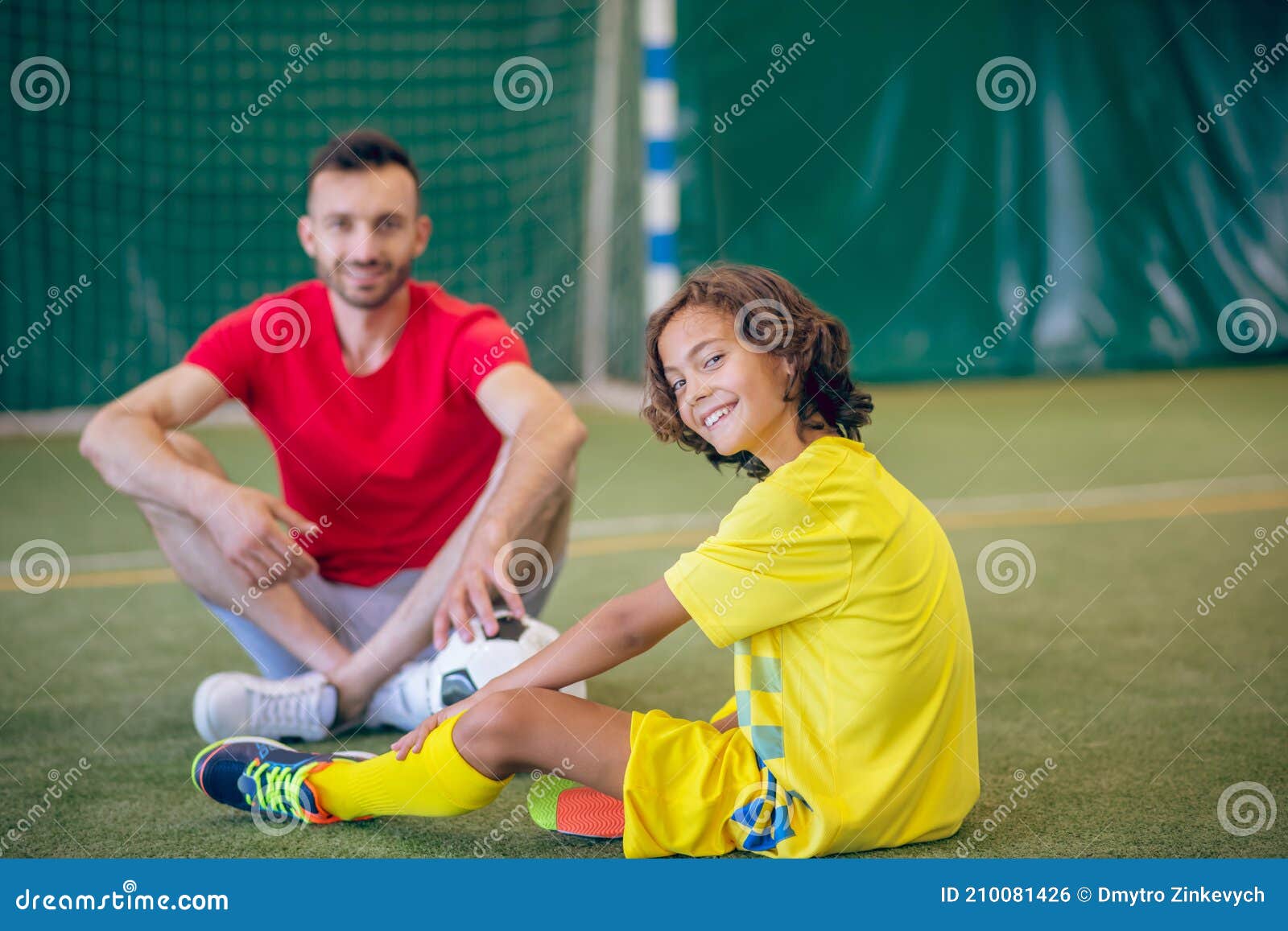 Boy in Yellow Uniform and His Coach Resting after the Game and Smiling ...