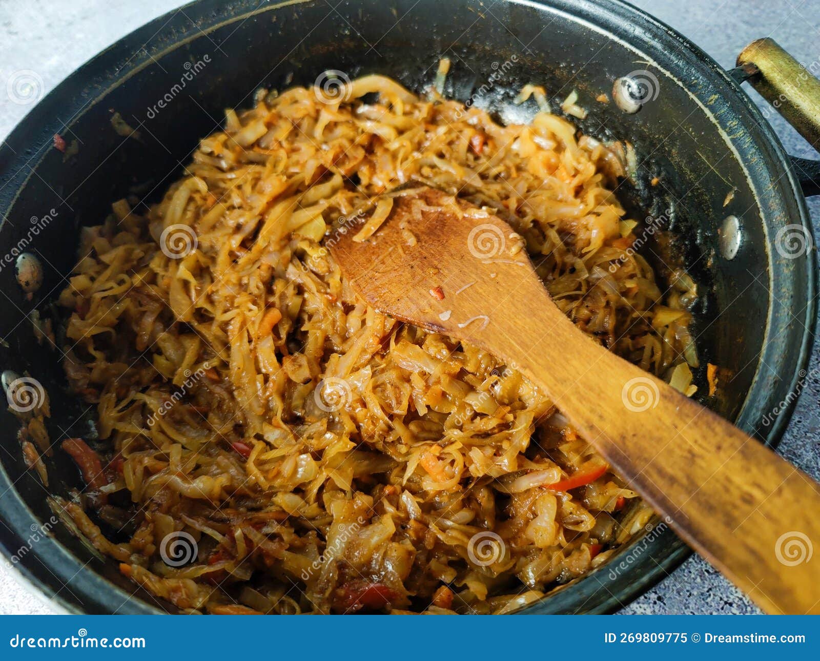 Braised Cabbage in a Pan on a Gray Surface with a Wooden Spatula. View ...