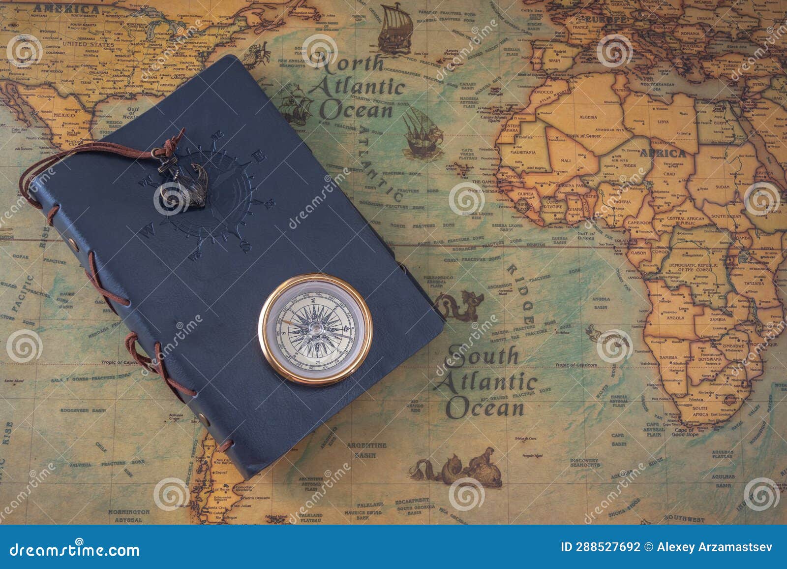 Brass Compass and a Leather-bound Book Lie on an Old Map. Stock Photo ...