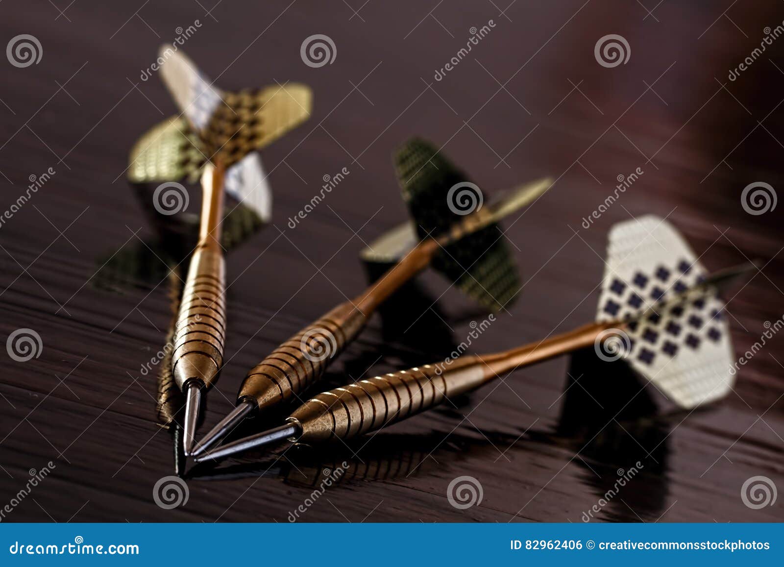 Brass Gold Darts On Brown Table Picture. Image: 82962406