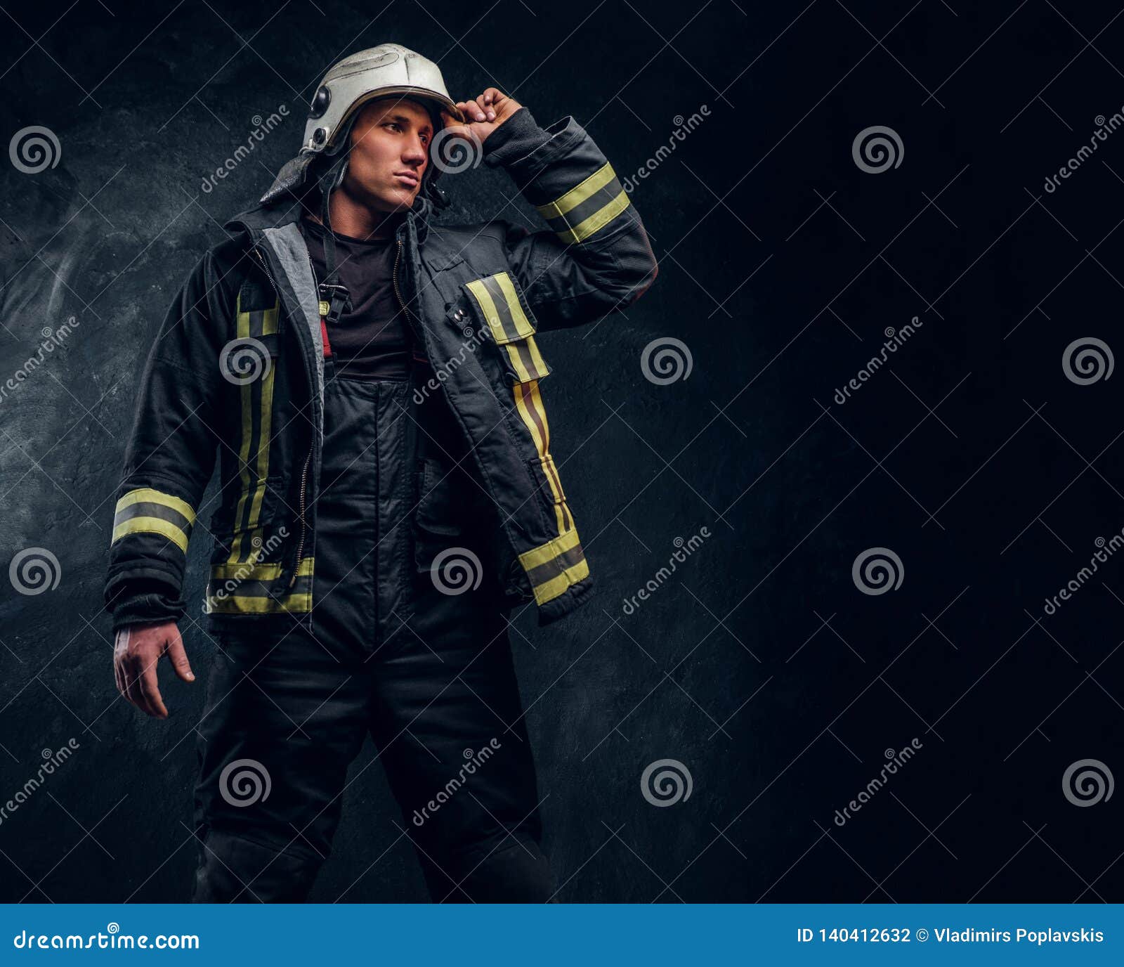 Brave Fireman in a Fire Suit Looking Sideways and Correcting the Helmet ...